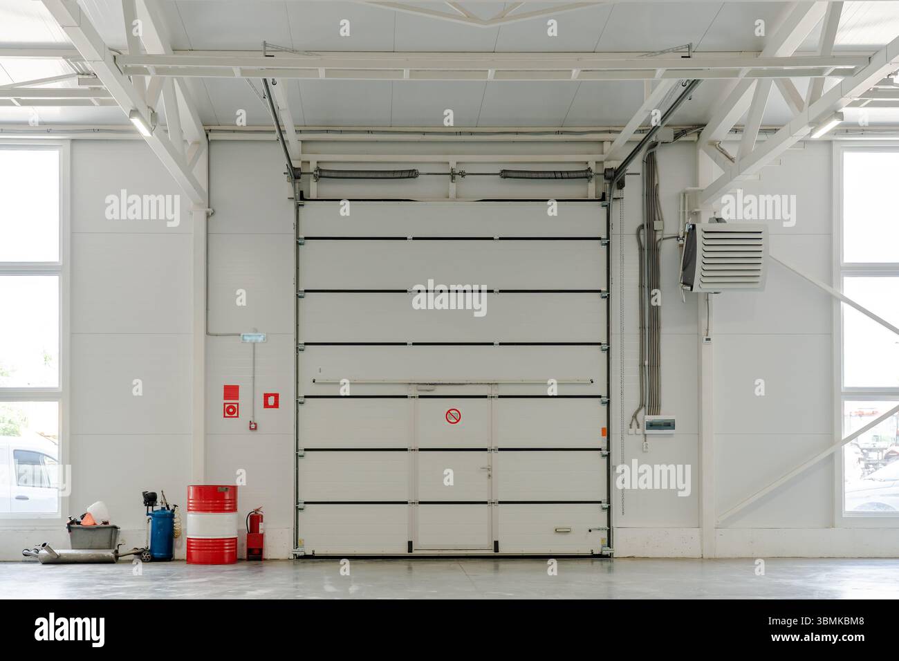 Industrial garage door in modern warehouse interior with fire safety ...