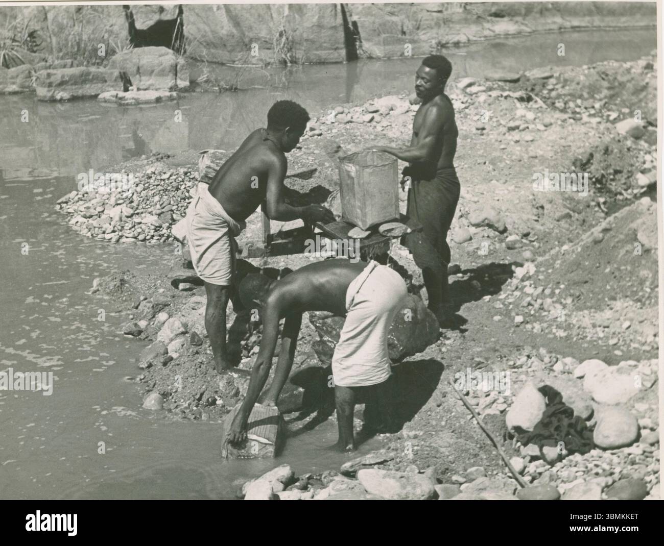 Some men sift and wash the soil to extract alluvial gold on the Lupa ...
