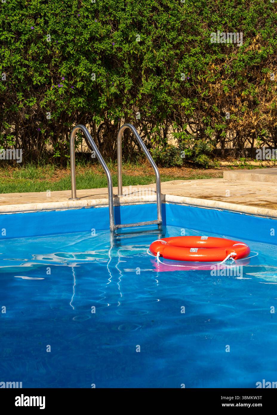 Lifebuoy floats in blue swimming pool, symbolizing water safety and ...