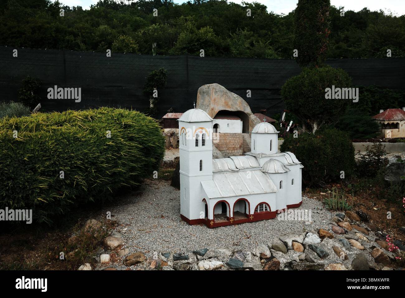 A white miniature Orthodox church with twin towers and red details, set ...