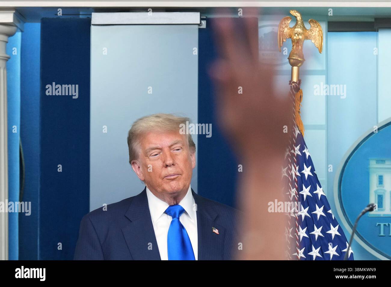 President Donald Trump looks on as reporters raise their hands to ask ...