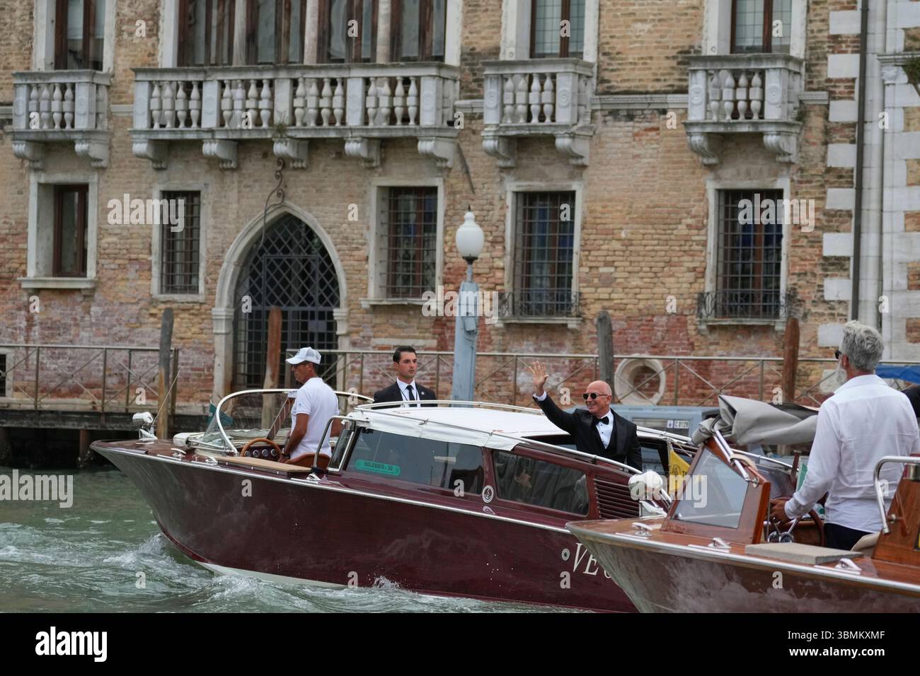 Jeff Bezos waves as he leaves a hotel ahead of the anticipated wedding ...