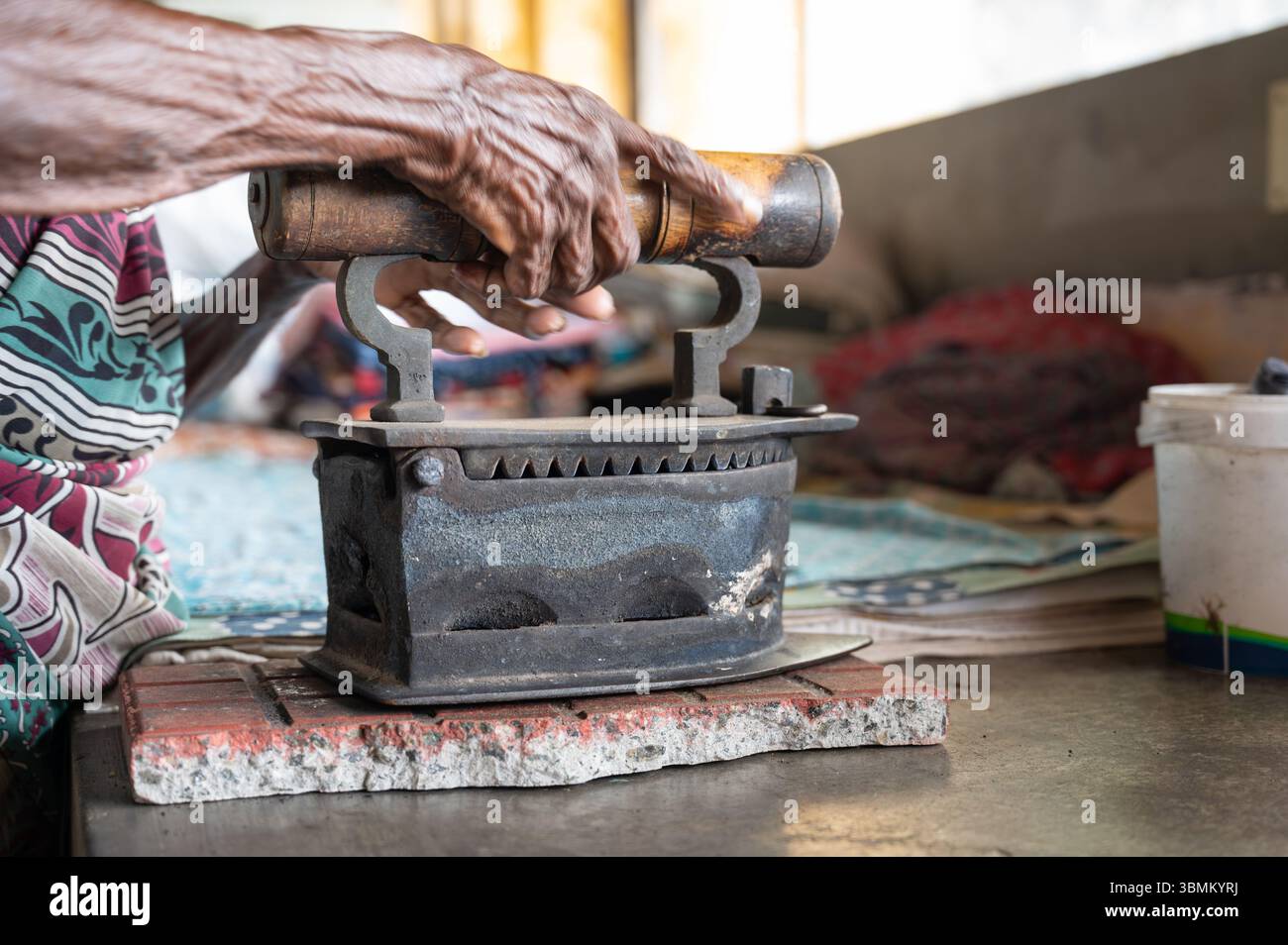 Woman in traditional clothes irons with an antique charcoal iron, Dhobi ...