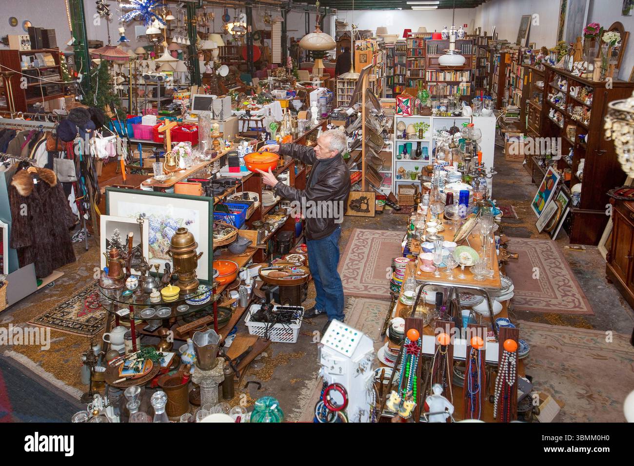 Netherlands - Interior of a thrift store, where the manager is sorting ...