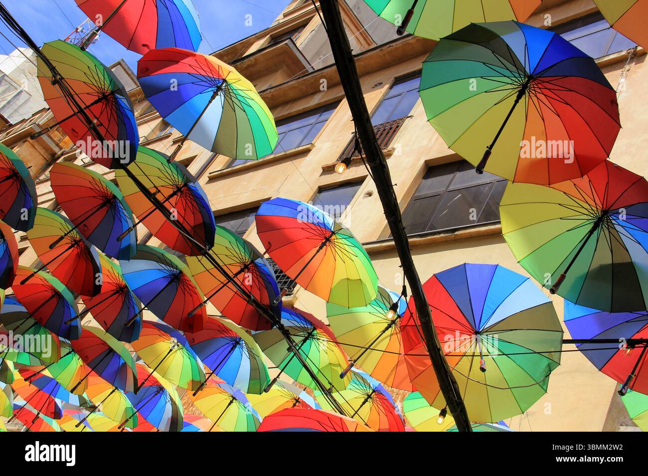 Colorful canopy of umbrellas suspended over the street Stock Photo - Alamy