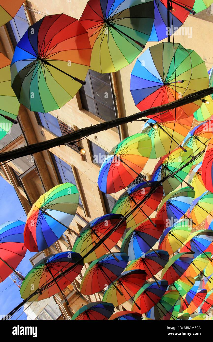 Colorful canopy of umbrellas suspended over the street Stock Photo - Alamy