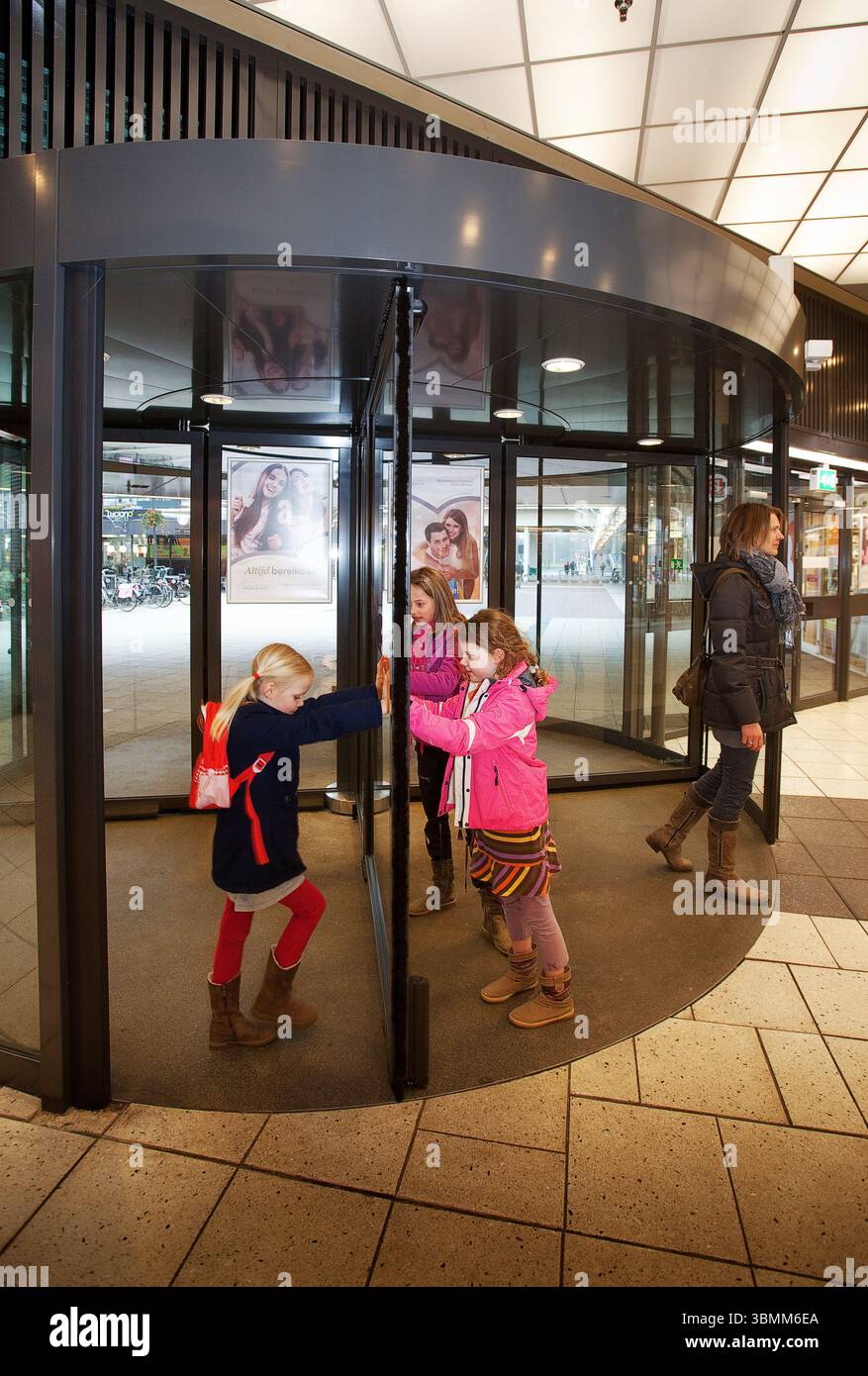 Netherlands, Arnhem. Children play with the revolving doors at the ...