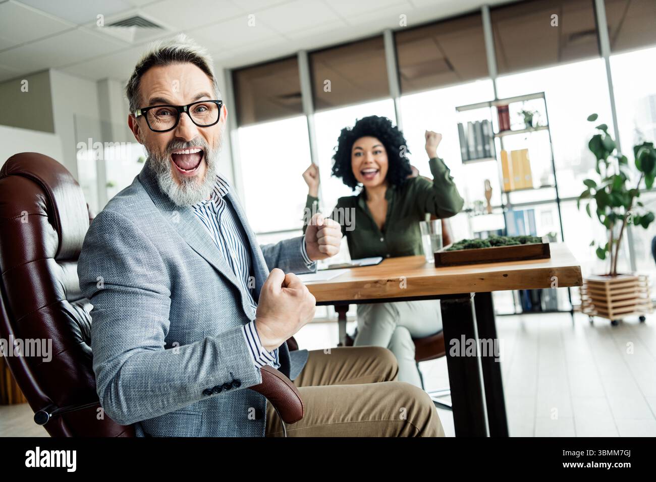 Exciting moment in a modern office as colleagues celebrate success and ...