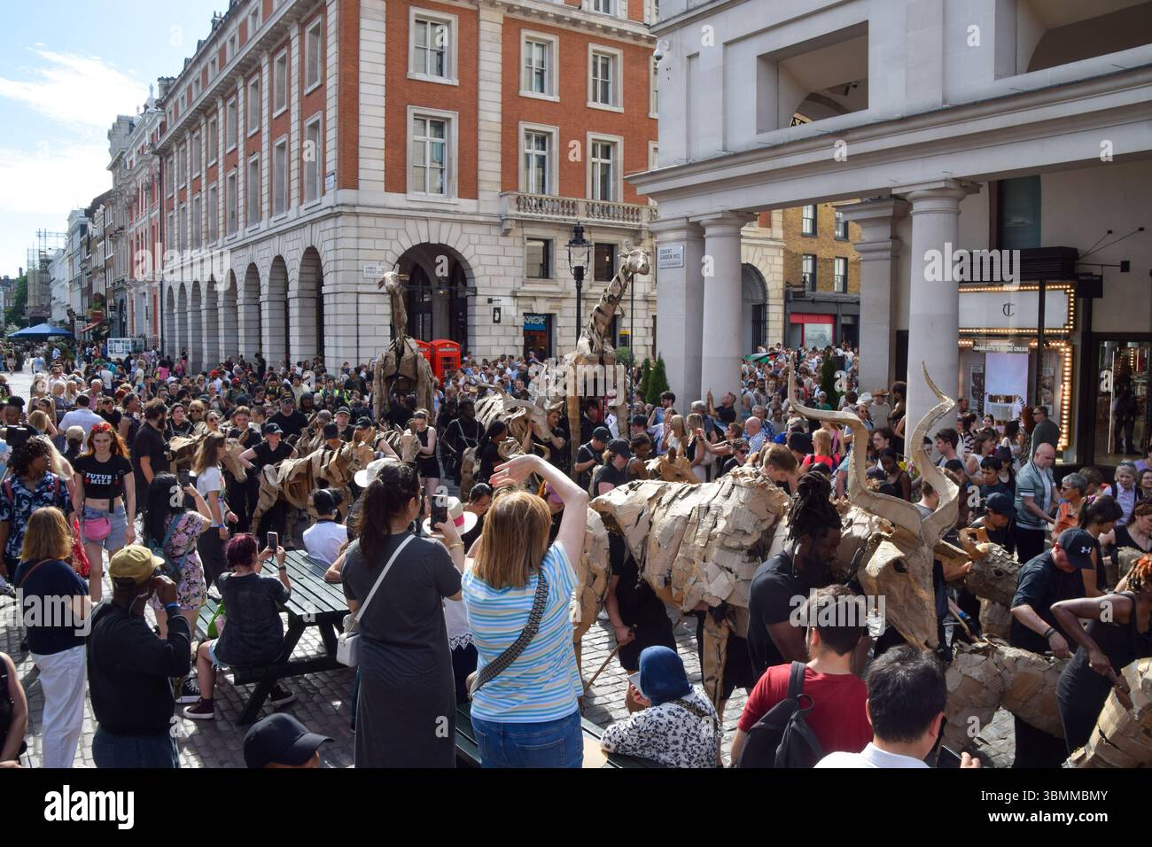 London, UK. 27th June 2025. Puppeteers walk with life-size animal ...
