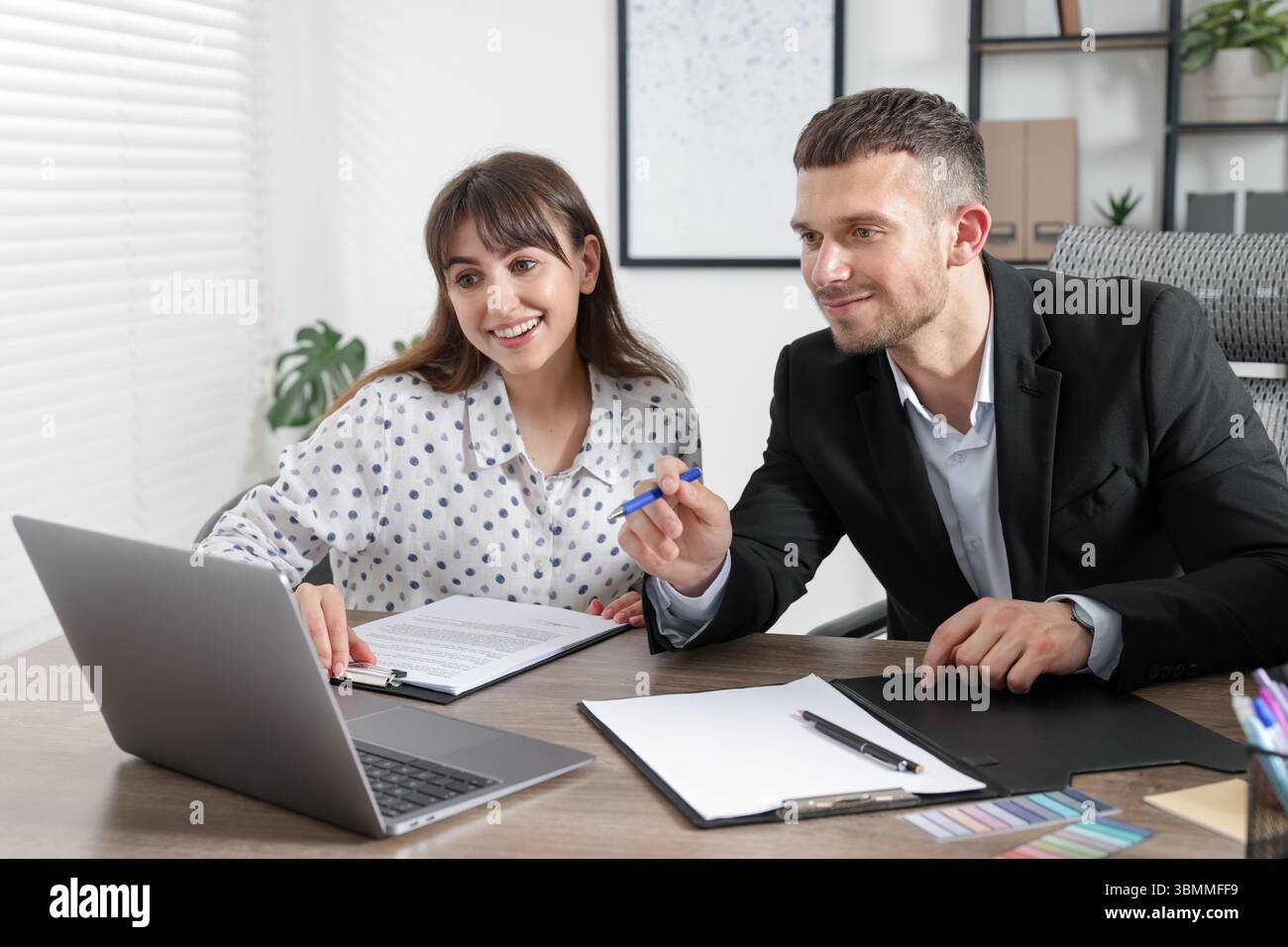 Consultant working with client at table in office. Business meeting ...