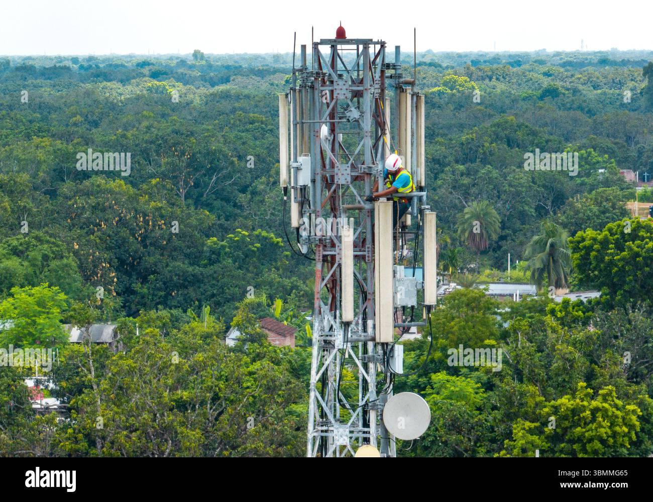 Technicians climbing network tower with safety gears, fixing mobile ...
