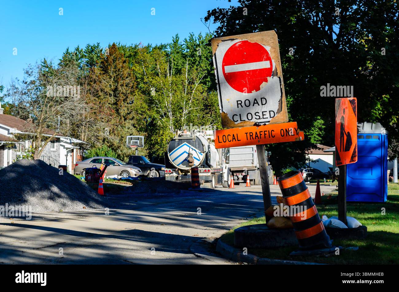 Morning sunlight on a road closed sign on a residential street ...