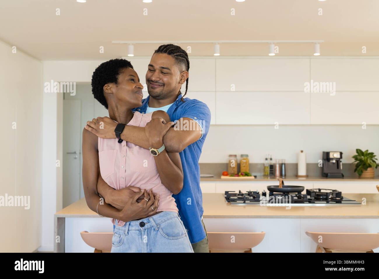 Hugging Diverse couple wrapping arms around partner on island in modern ...