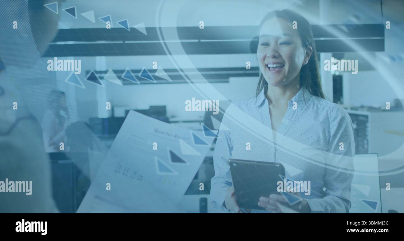 Smiling Korean woman holding tablet and receiving report in open office ...