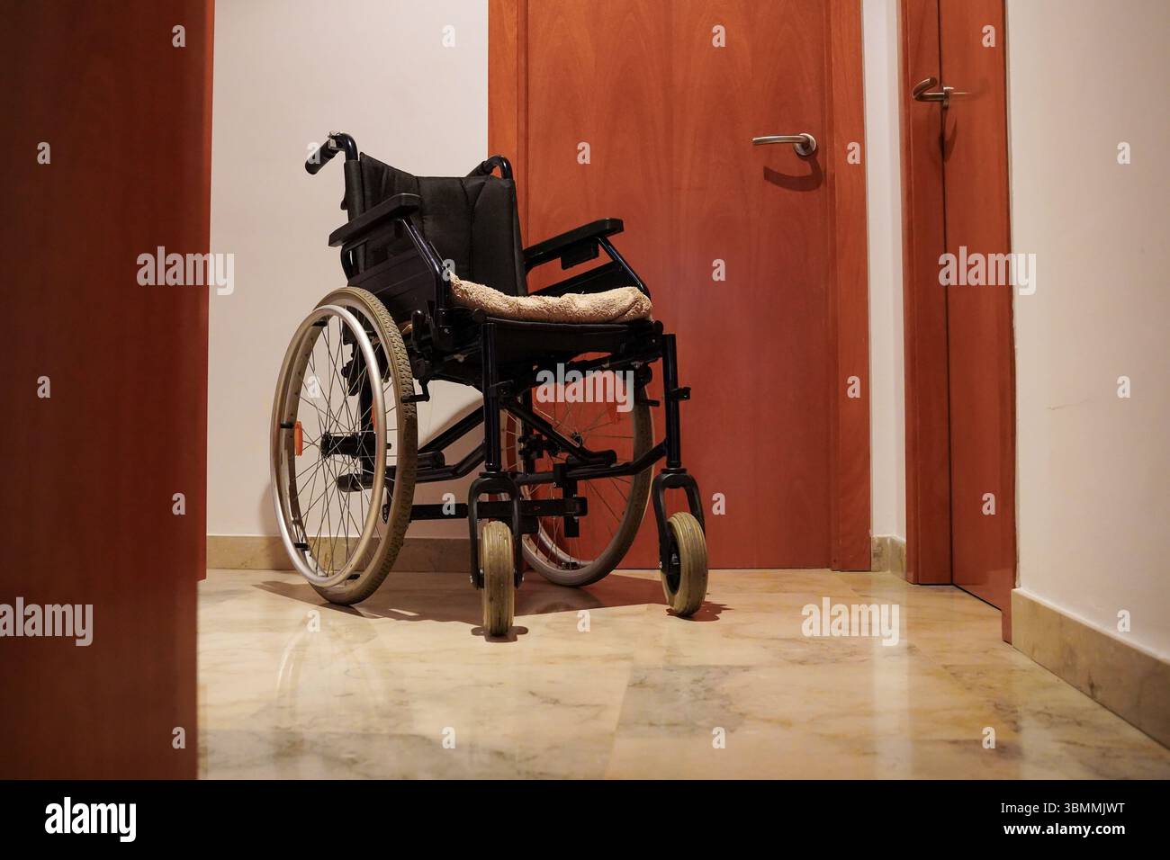 Wheelchair left in corridor of private home Stock Photo - Alamy
