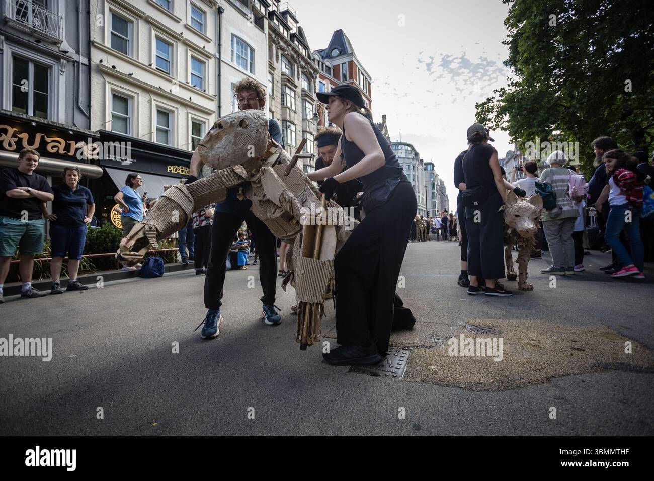 LONDON, UK – 27 June 2025: Performers manoeuvre life-size cardboard ...