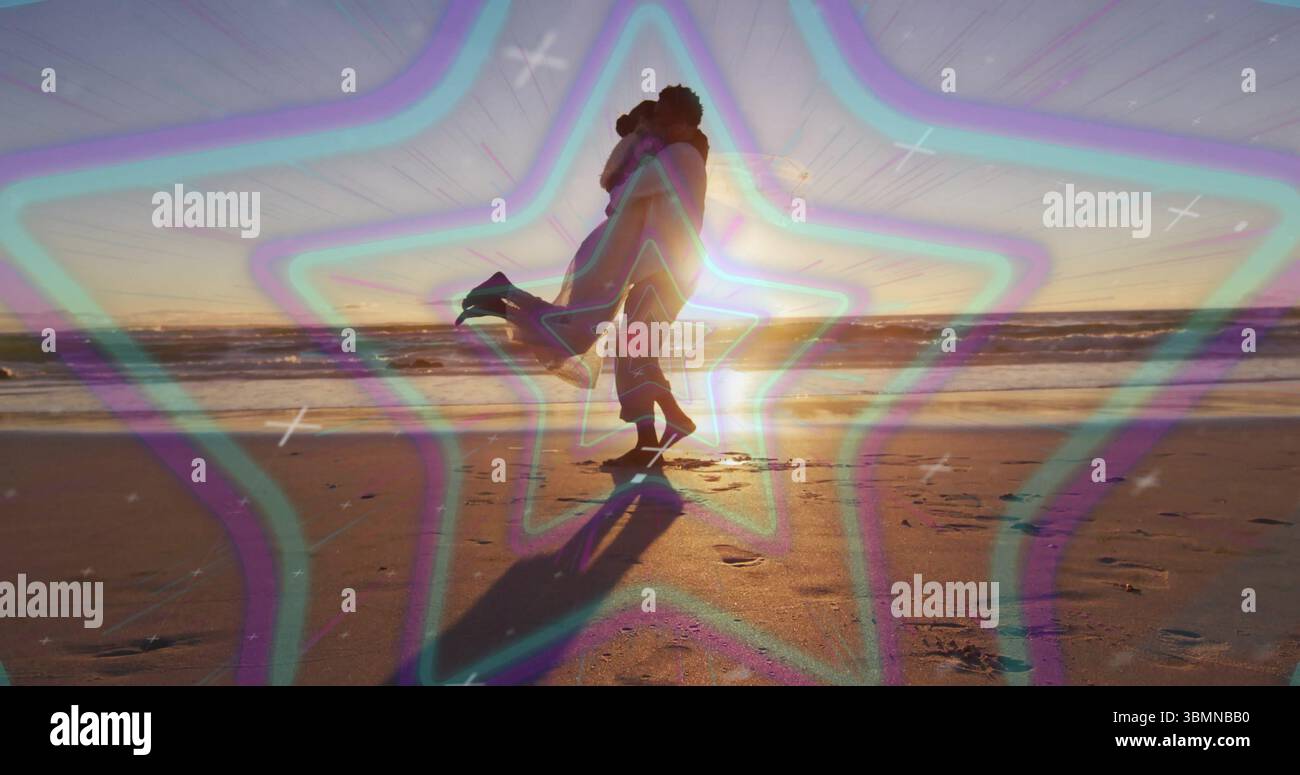 Embracing couple lifting woman off feet on sandy beach at sunset, with ...
