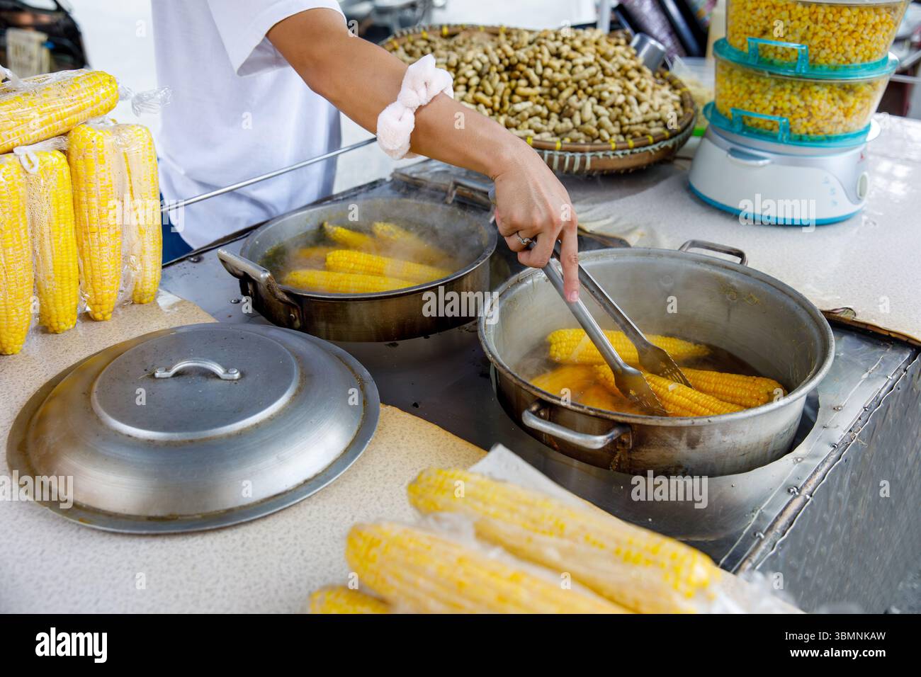 Filipino vendor boiling corn on street food stall with peanuts and ...