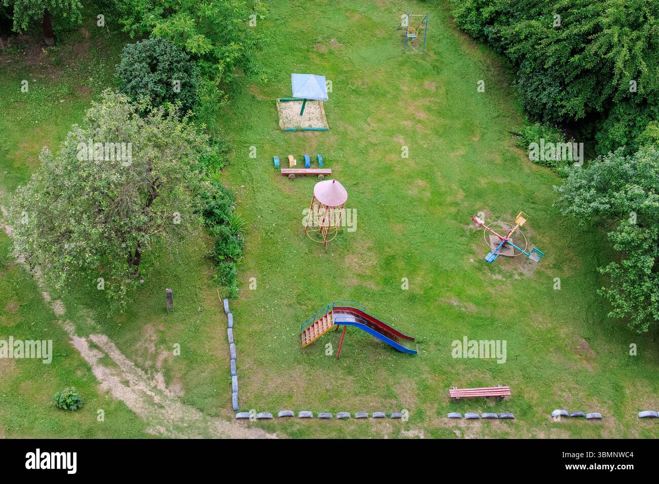 Top-down view of a vintage outdoor playground surrounded by grass and ...