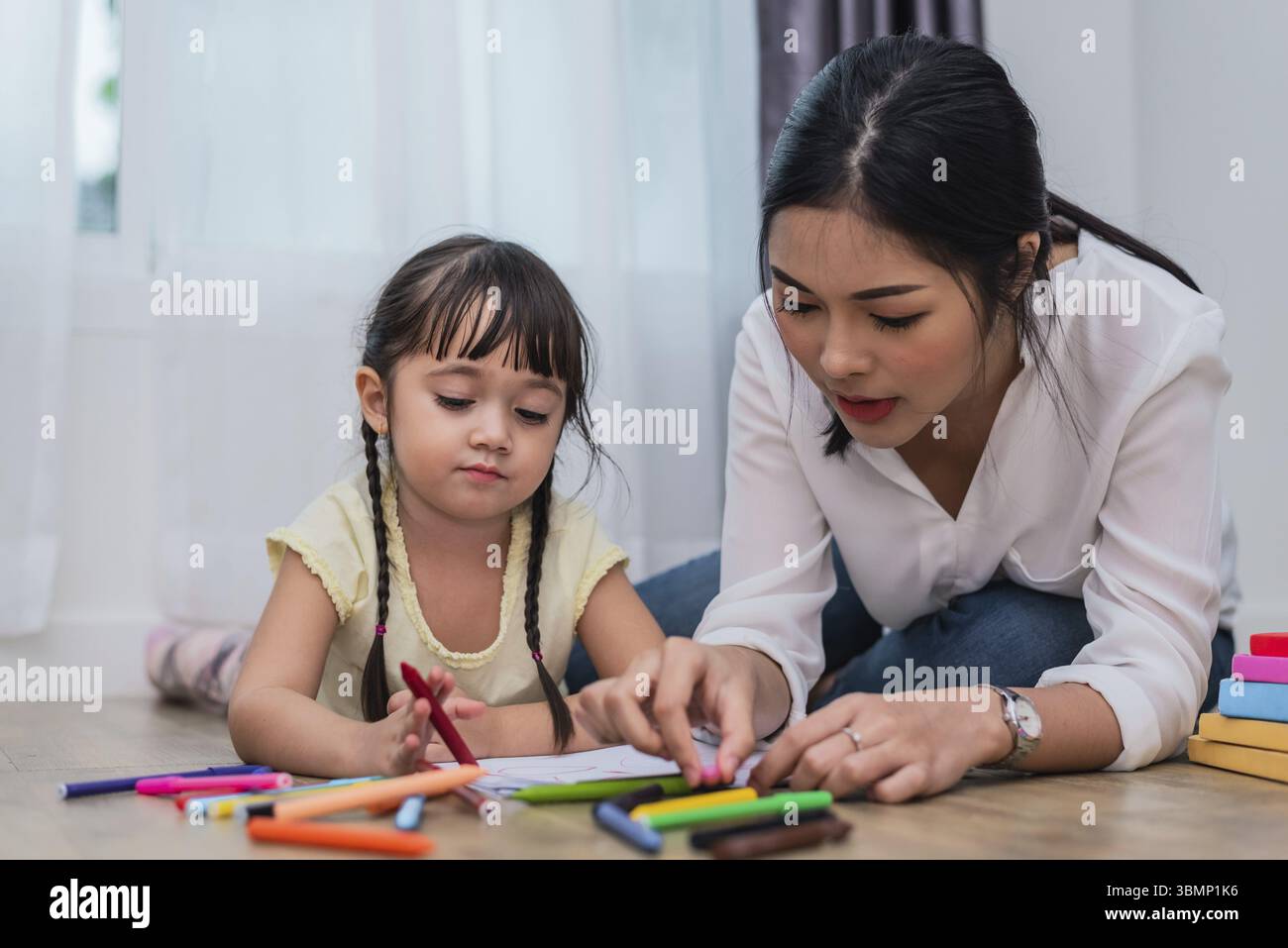 Mother teaching girl in drawing class. Daughter painting with colorful ...