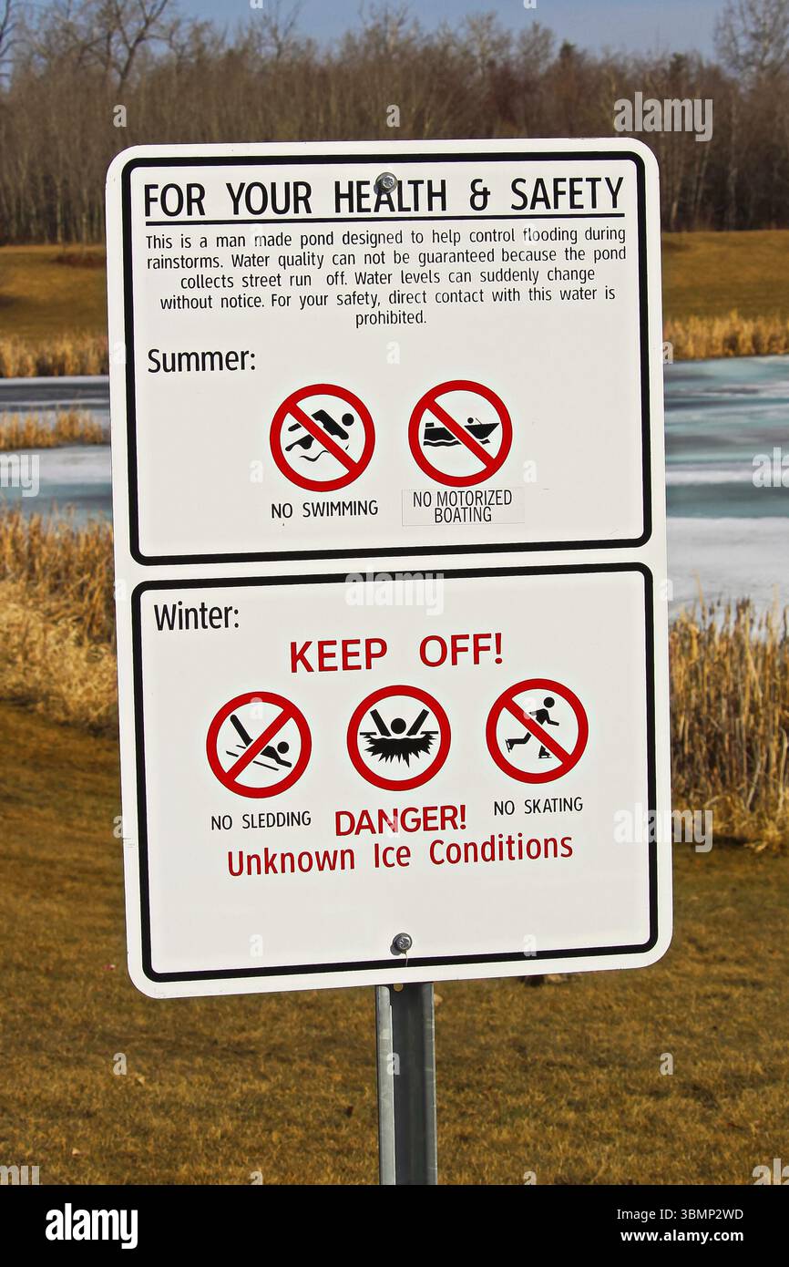 Warning signs around storm drainage pond Stock Photo - Alamy
