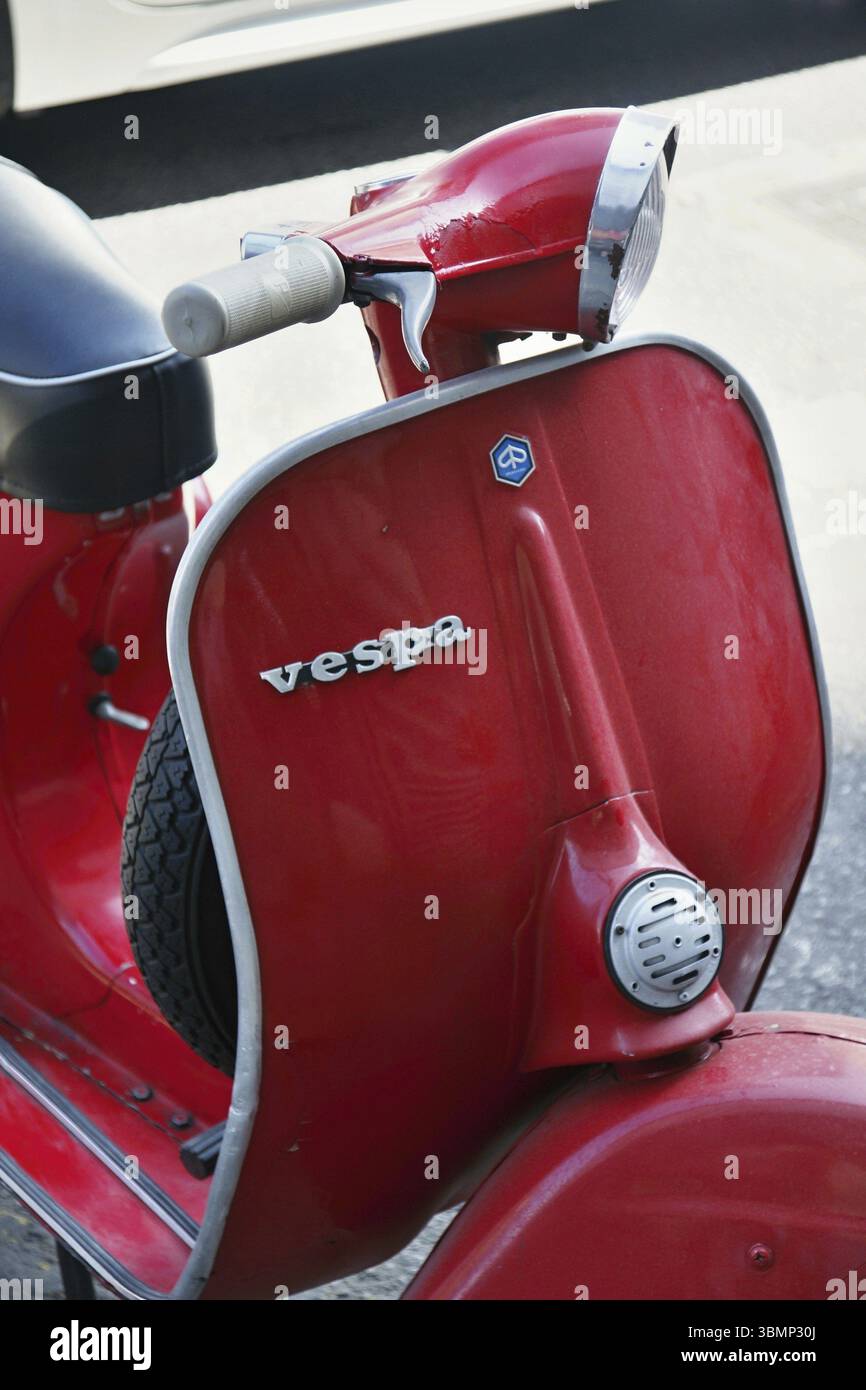 Classic red Vespa scooter parked on a street, showcasing its vintage ...