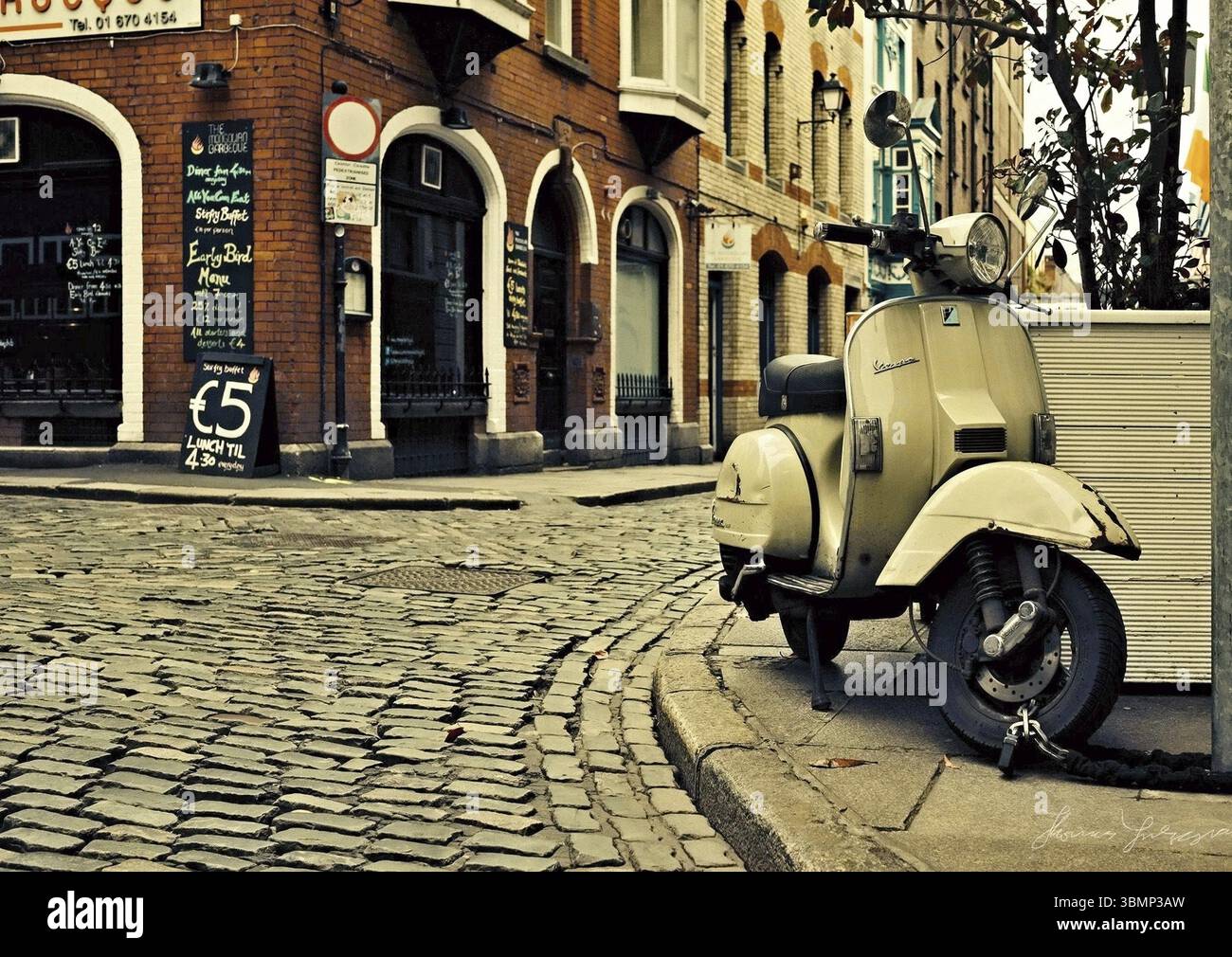 Classic Vespa scooter parked on a charming cobblestone street in Dublin ...