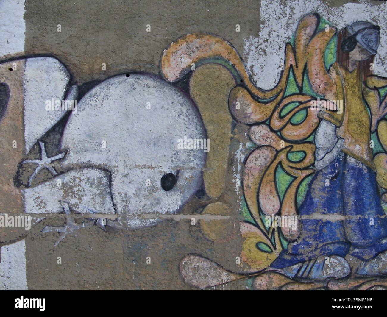 Graffiti artist wearing headphones is painting colorful urban art on a ...