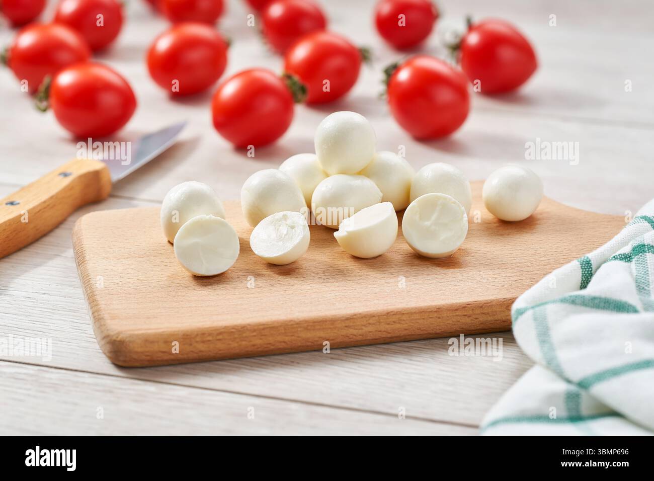 baby mozzarella cheese balls with cherry tomatoes on a kitchen table ...
