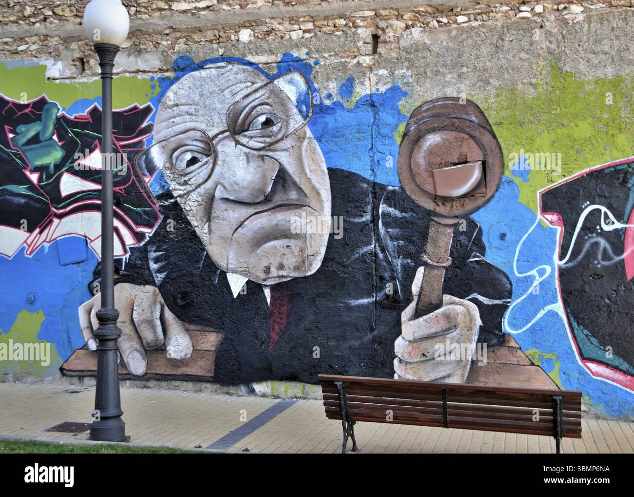 Graffiti art of a judge holding a gavel on a concrete wall with a ...