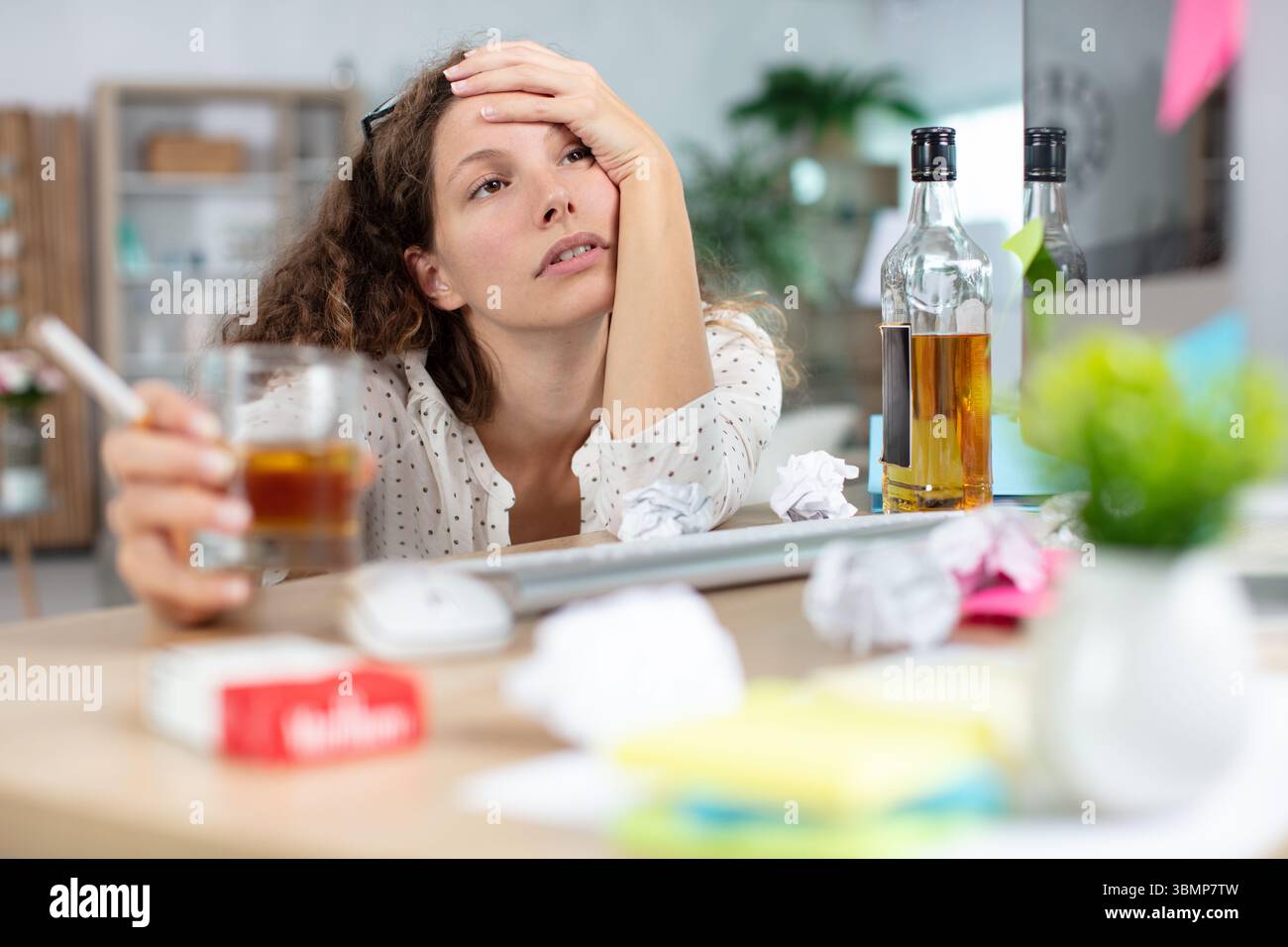 despairing woman at computer desk smoking and drinking alcohol Stock ...