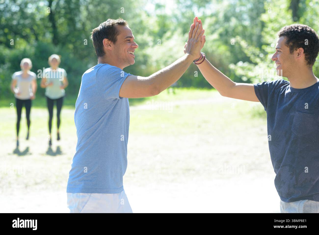active fit friends high five in celebration after completing workout ...