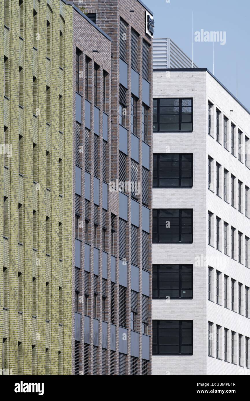 Newly built office buildings in green, grey-brown and white in a ...