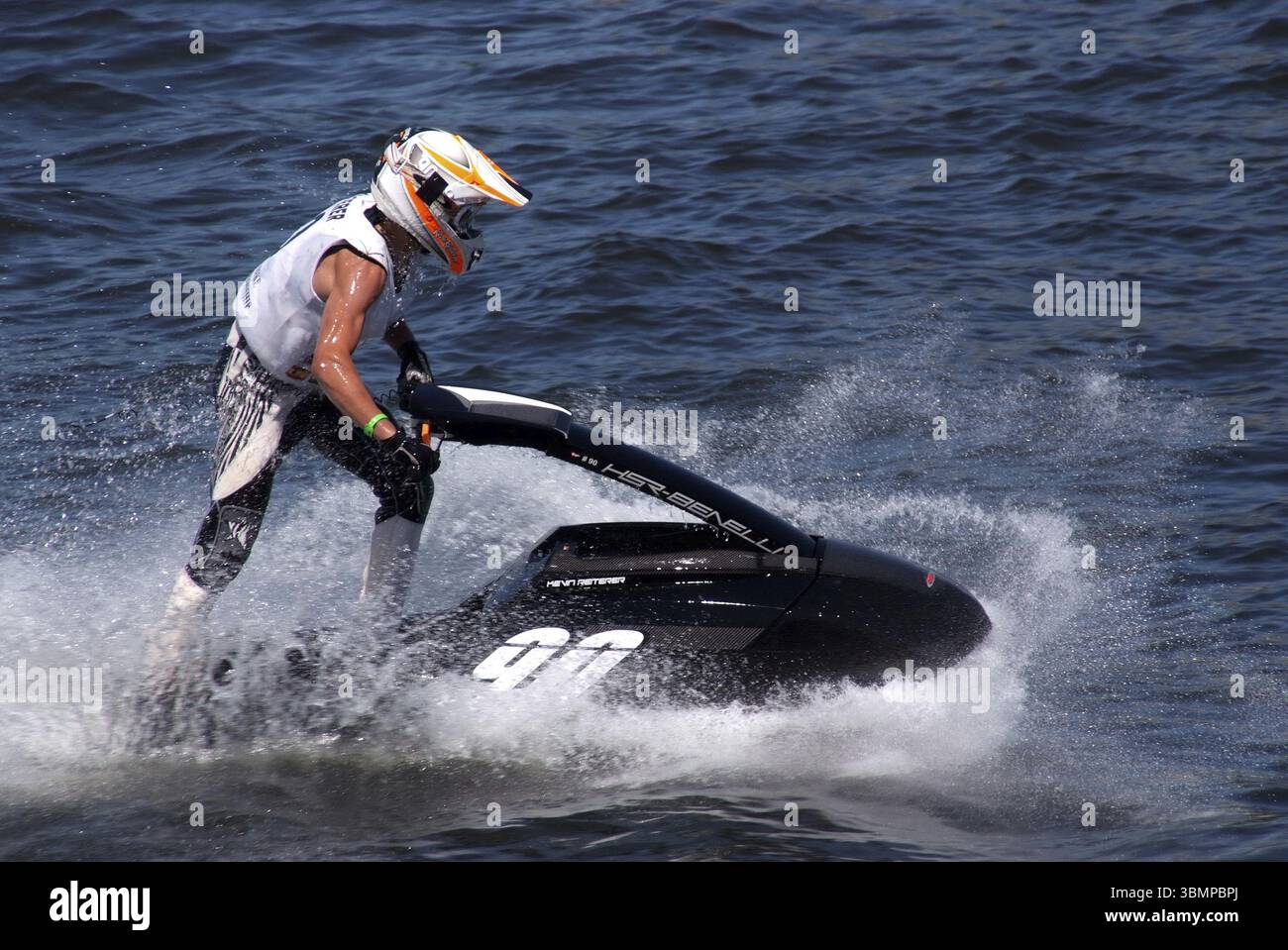 Professional pilot competing in a jet ski race, creating splashes of ...