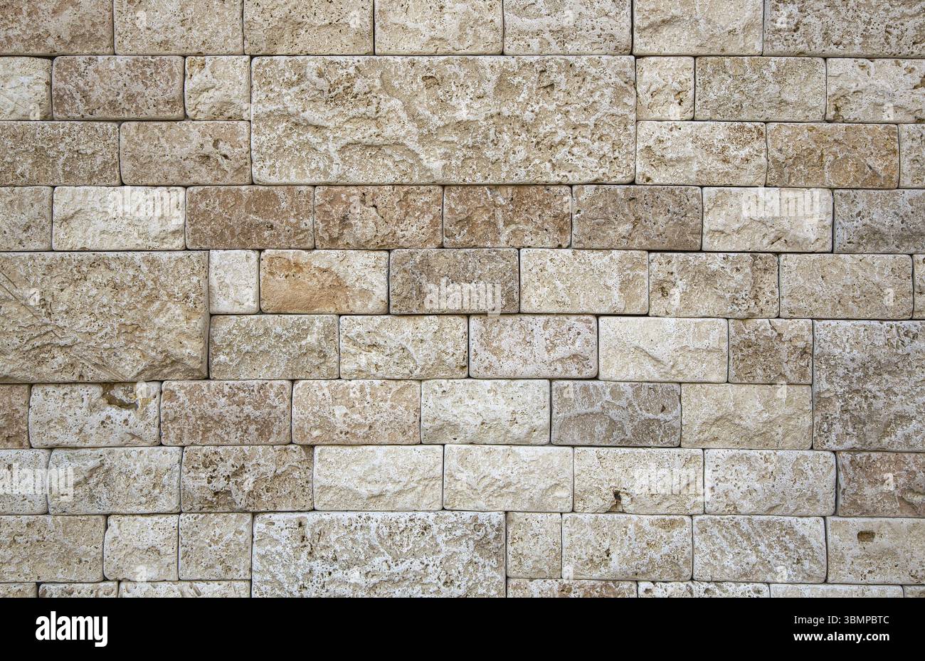 Part of the wall of natural stone beige porous structure. Finishing ...