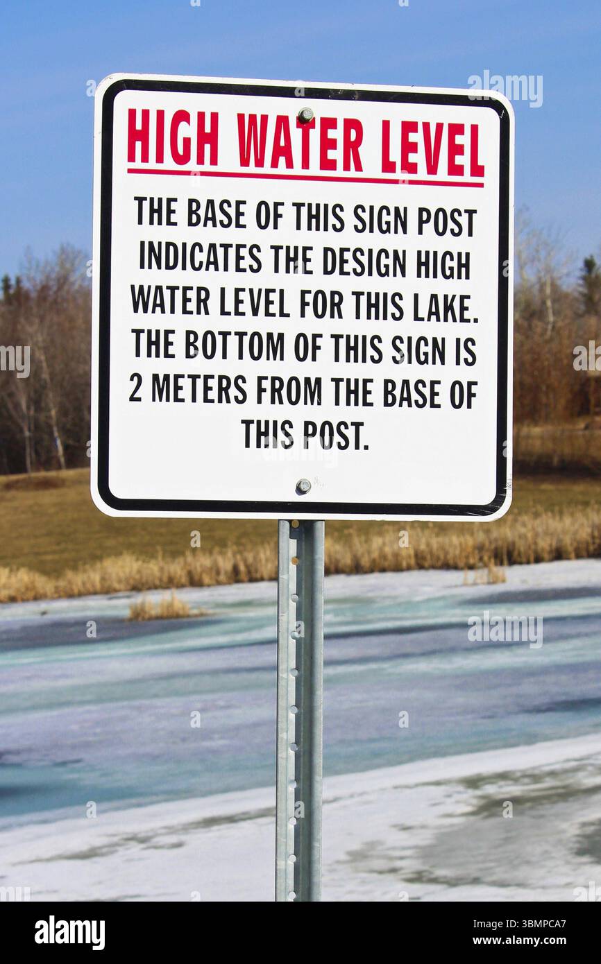 High water level sign along a storm drainage pond Stock Photo - Alamy
