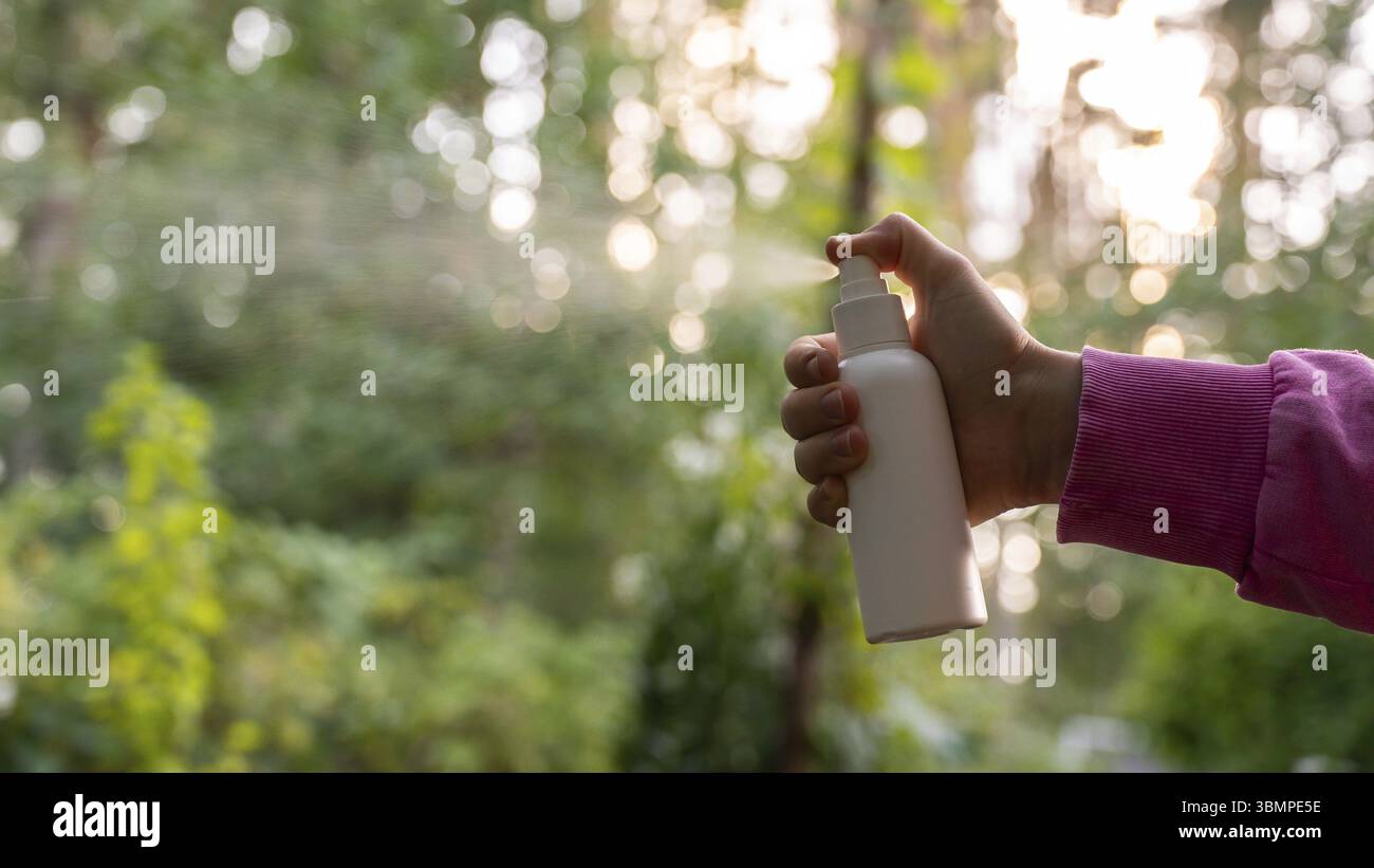 Hand applying insect repellent mosquito insecticide spray to kill flies ...