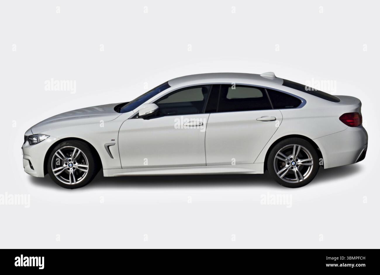 Side view of a white BMW 4 Series Gran Coupe parked on a white ...