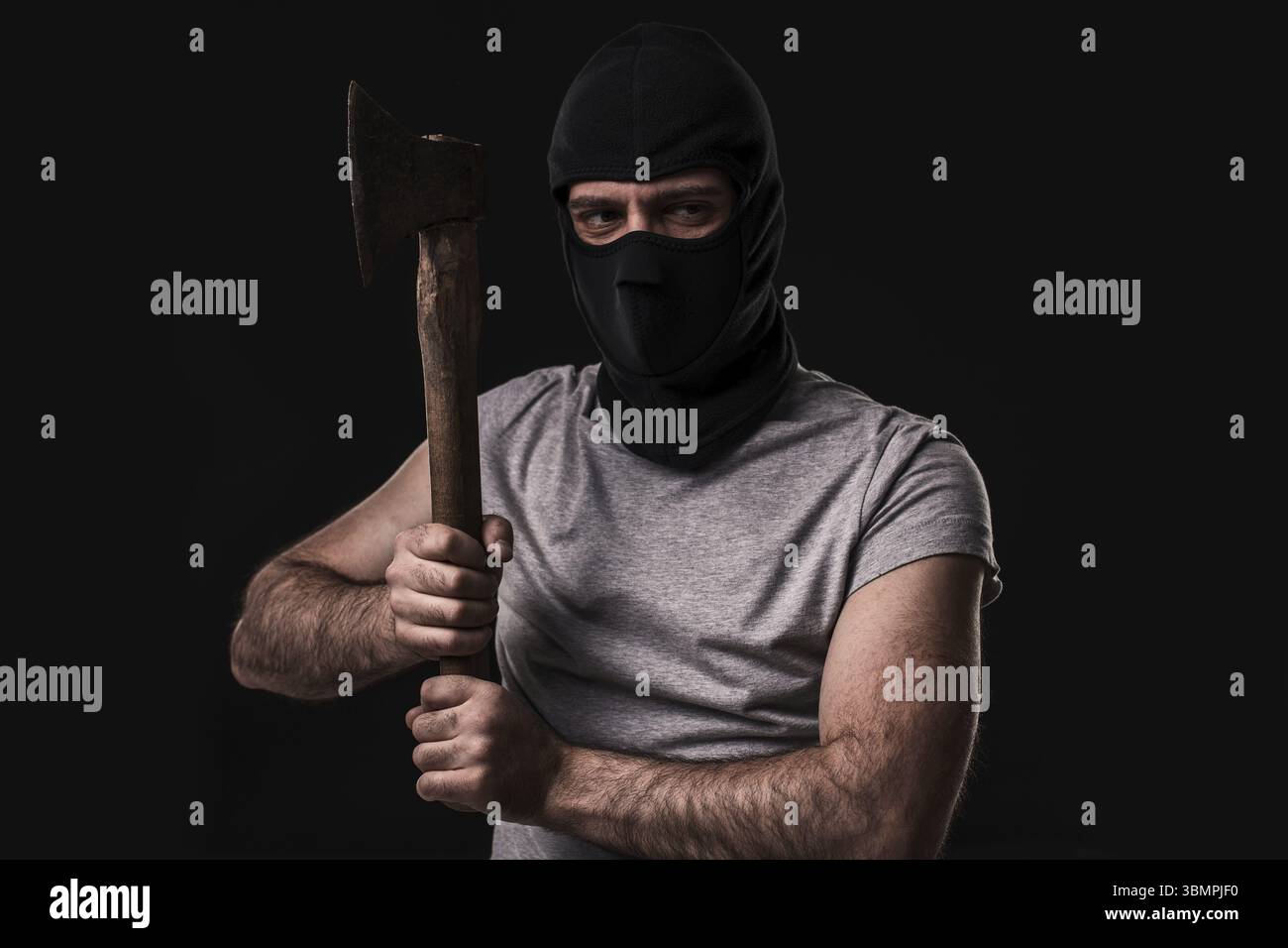 Bandit in black mask with hatchet on black background. Masked man with ...