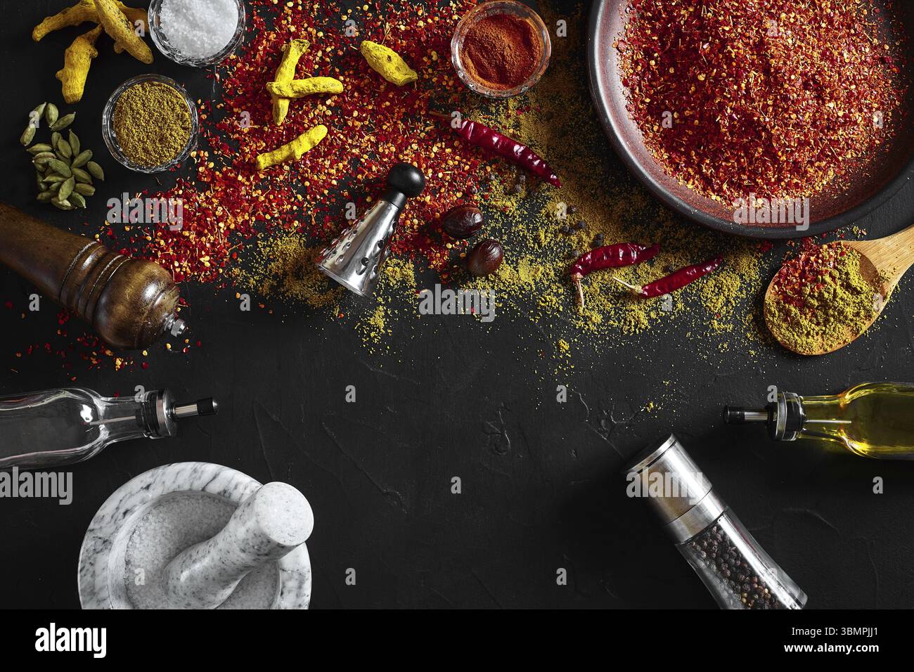 Cooking using fresh ground spices with mortar and small bowls of spice ...