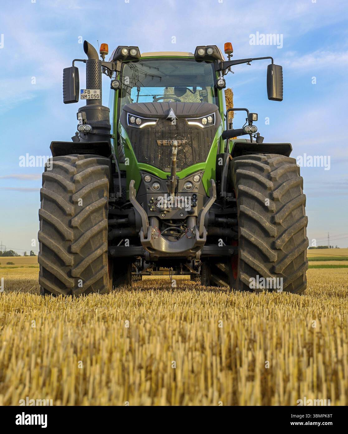 Green Fendt tractor standing on harvested wheat field with stubble in ...