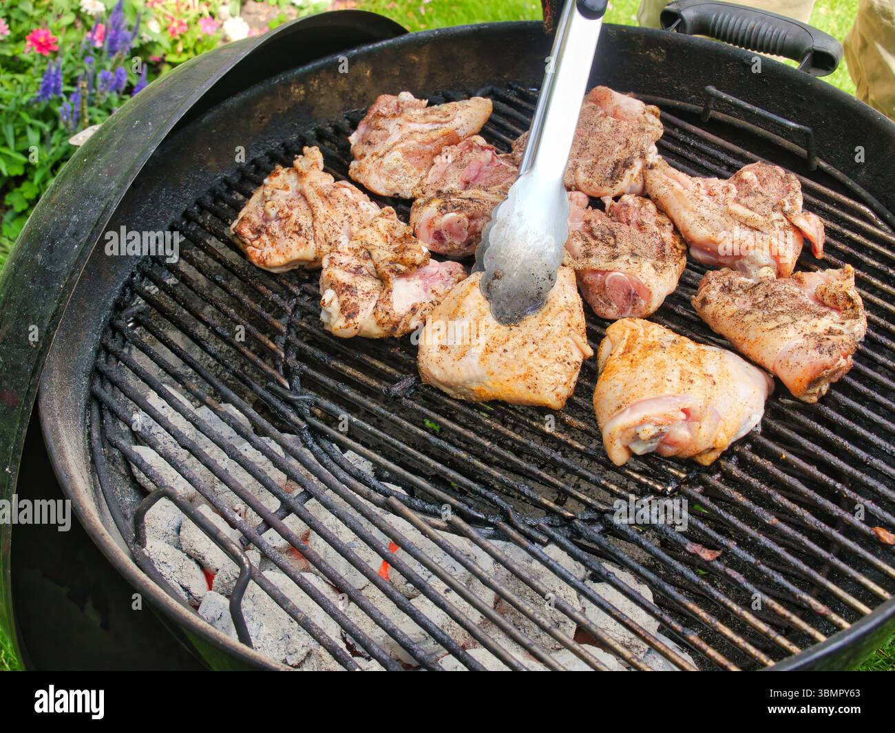 Using tongs turn chicken thighs hi-res stock photography and images - Alamy