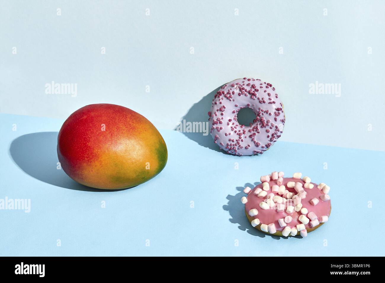 Composition of fresh fruits and sweets, two donuts and juicy mango on ...
