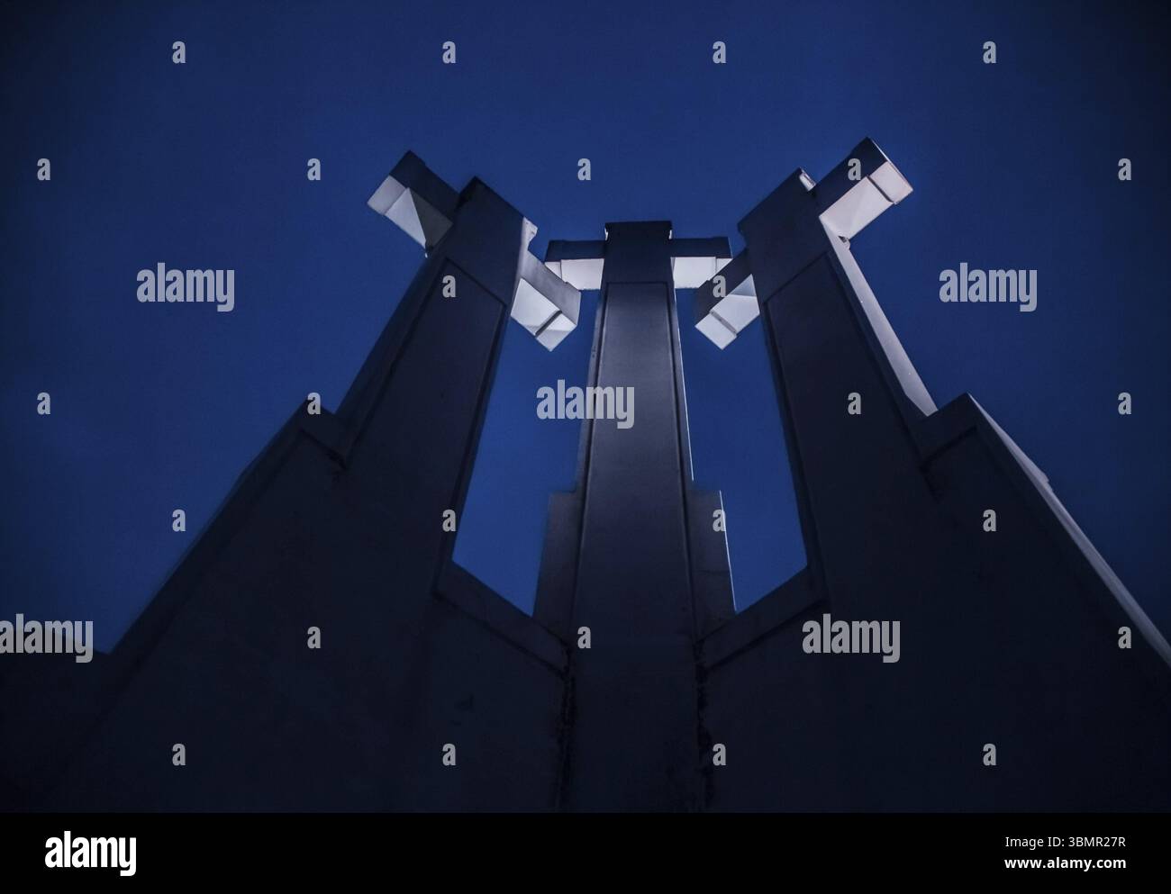 Three crosses illuminated in the night, view from below at the foot of ...