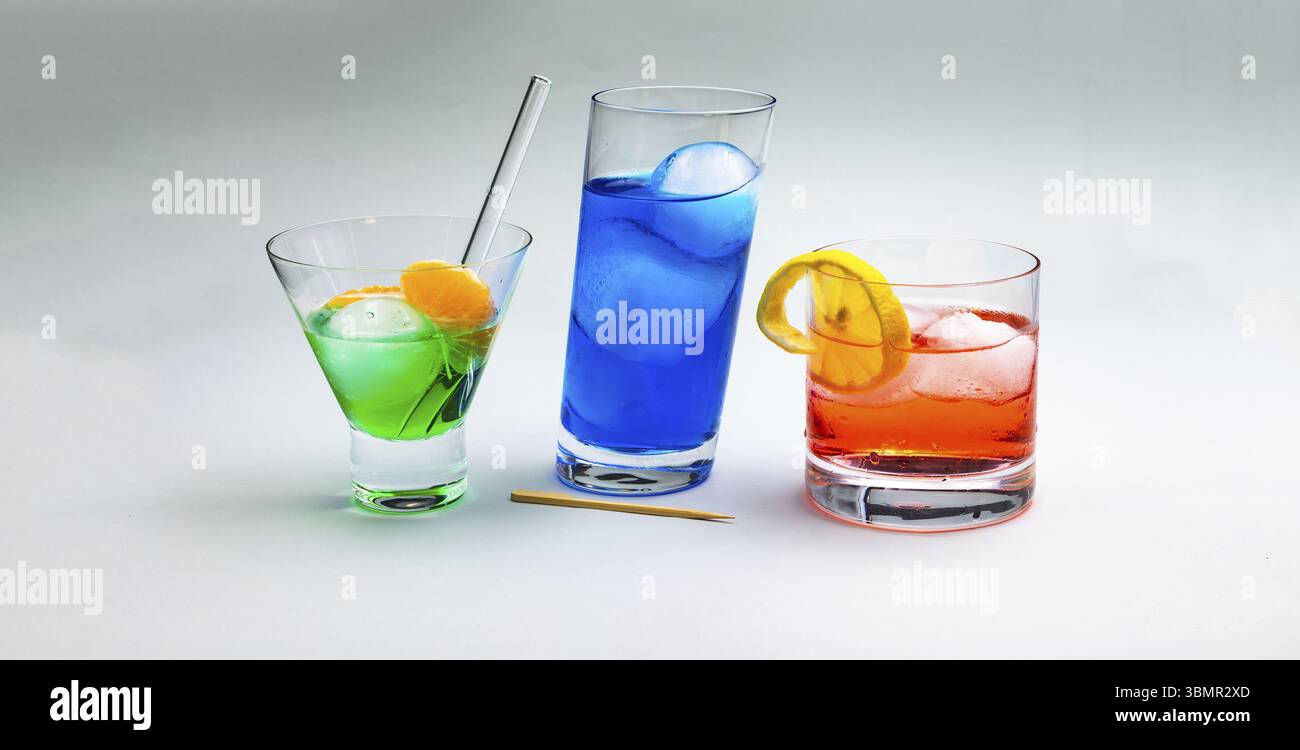 Three colorful long drinks with ice cubes released as a studio ...