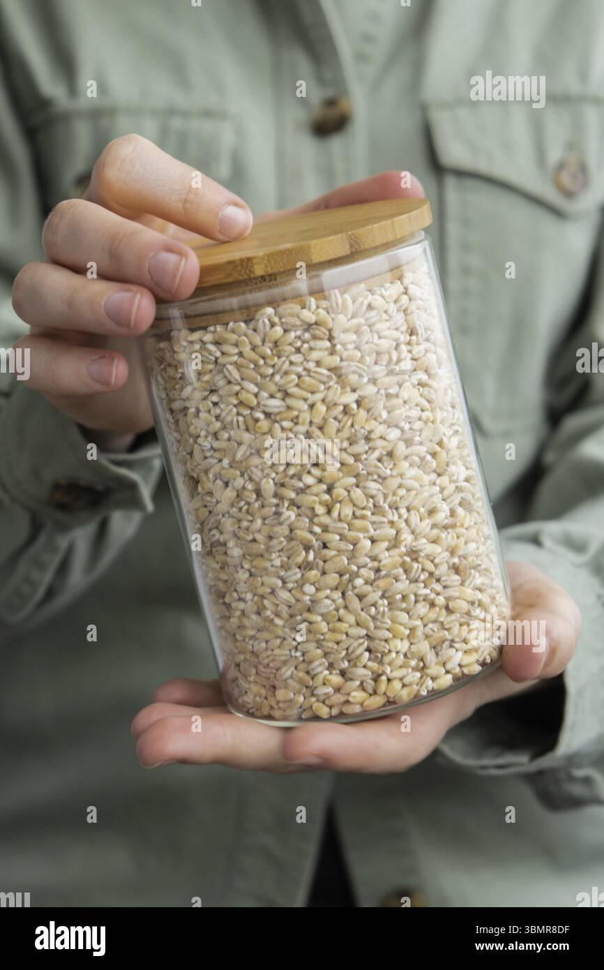 Woman holding Raw pearl barley porridge in sustainable natural ...
