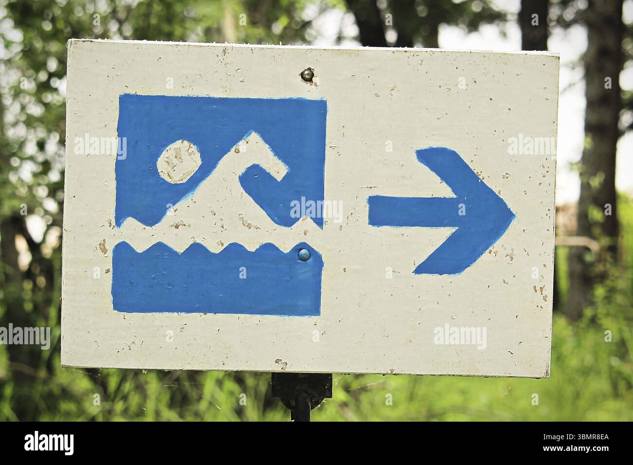 A blue beach beach sign with a direction arrow Stock Photo - Alamy