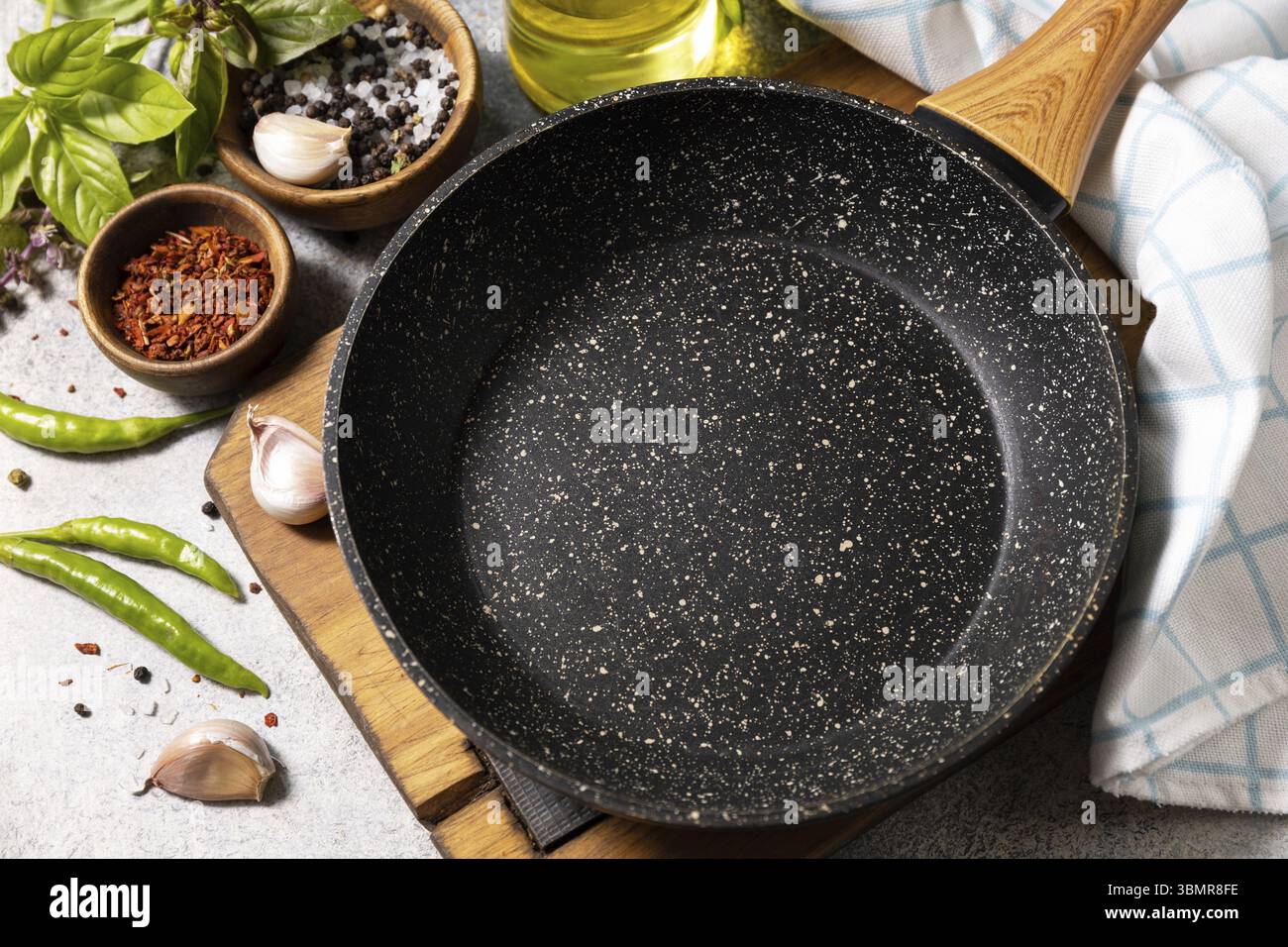 Empty skillet, vegetables, spices and herbs on gray stone background ...