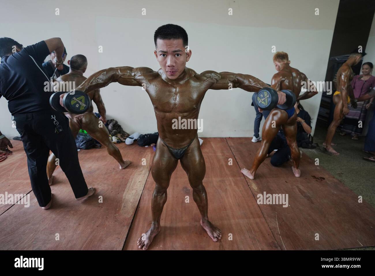 Contestants prepare at backstage during their bodybuilding competition ...