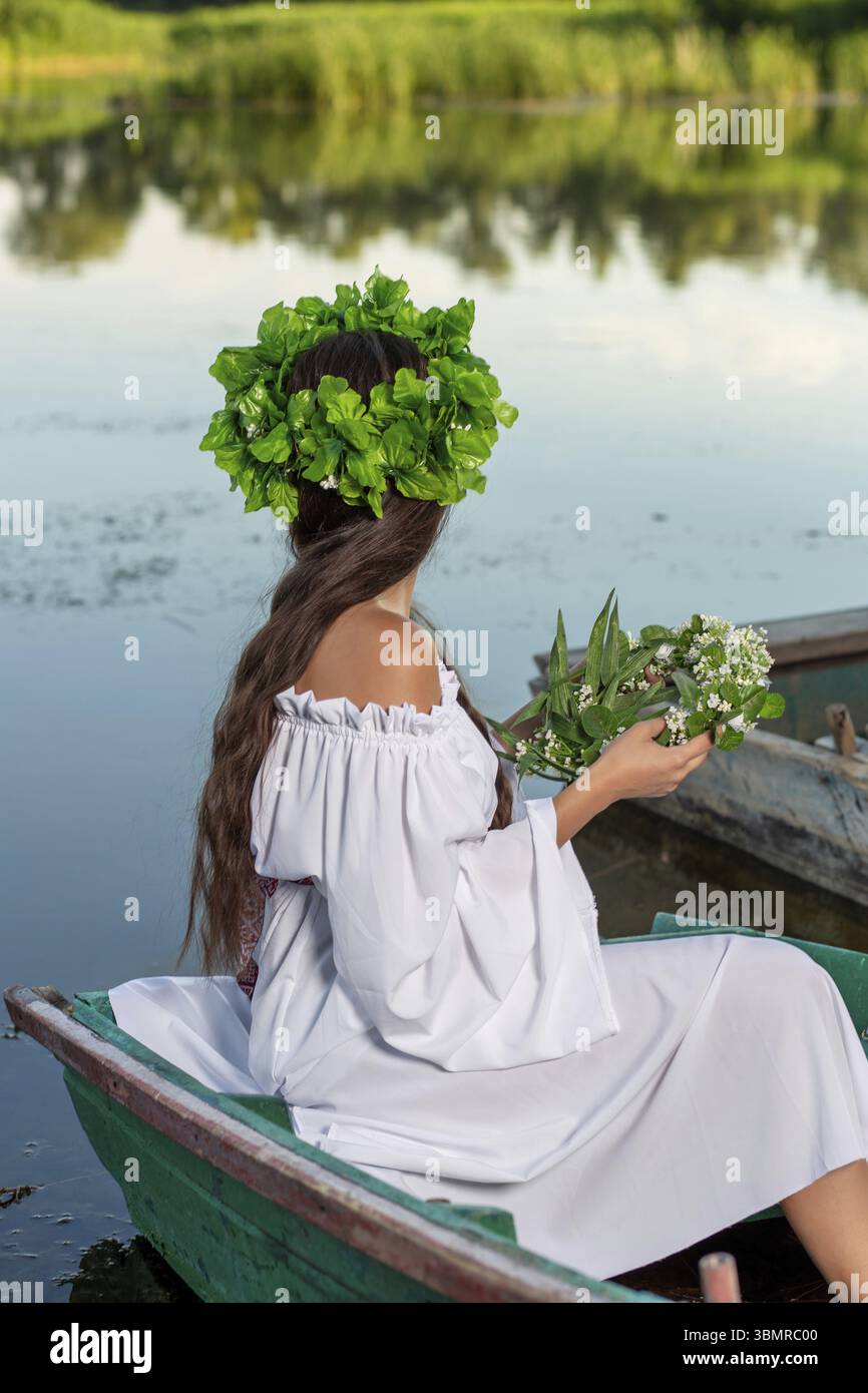 The nymph with long dark hair in a white vintage dress sitting in a ...